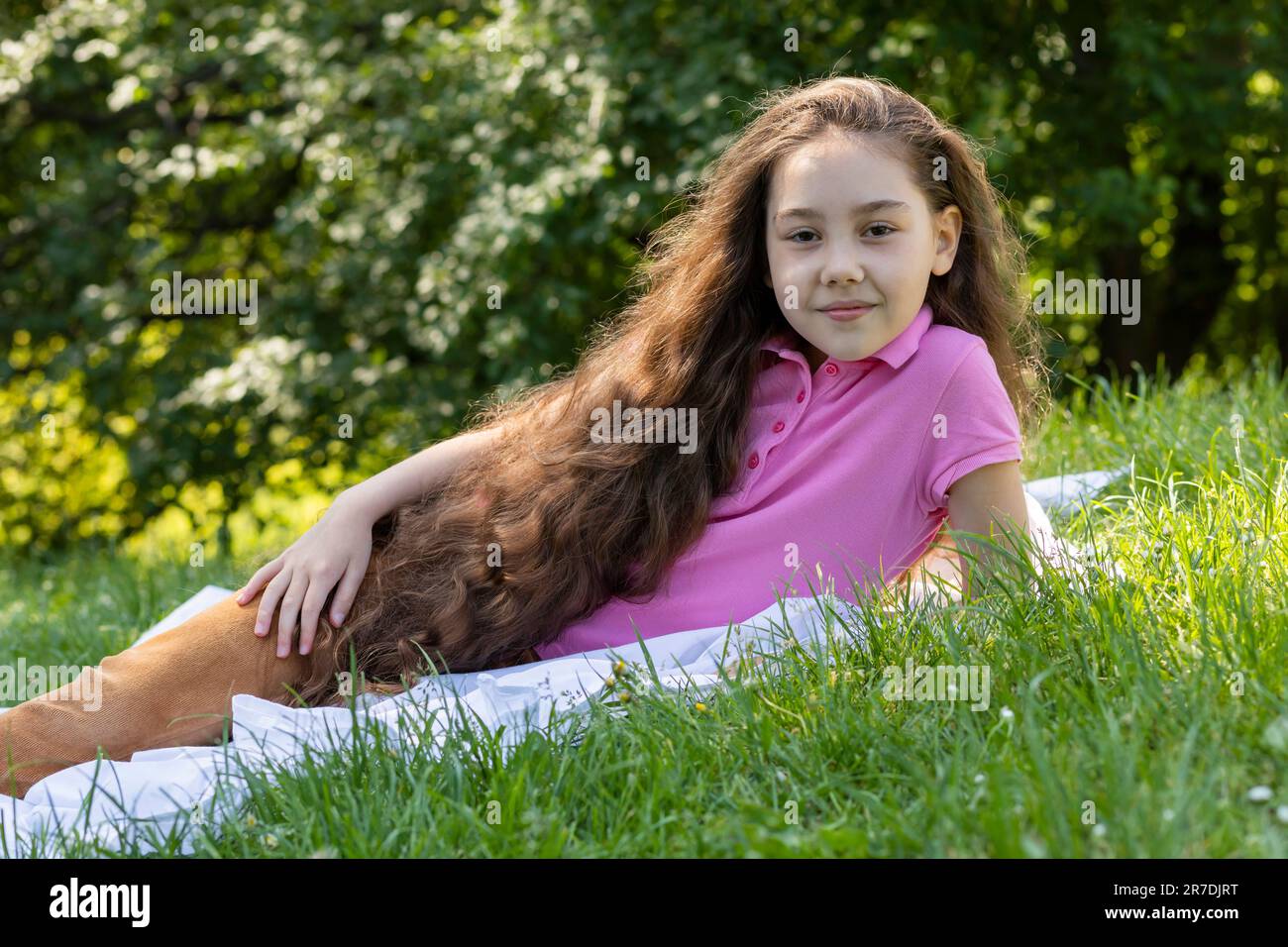 Little Adorable Girl With Extra Long Hair Lying On Grass in Meadow. Caucasian Asian Brown Haired ...