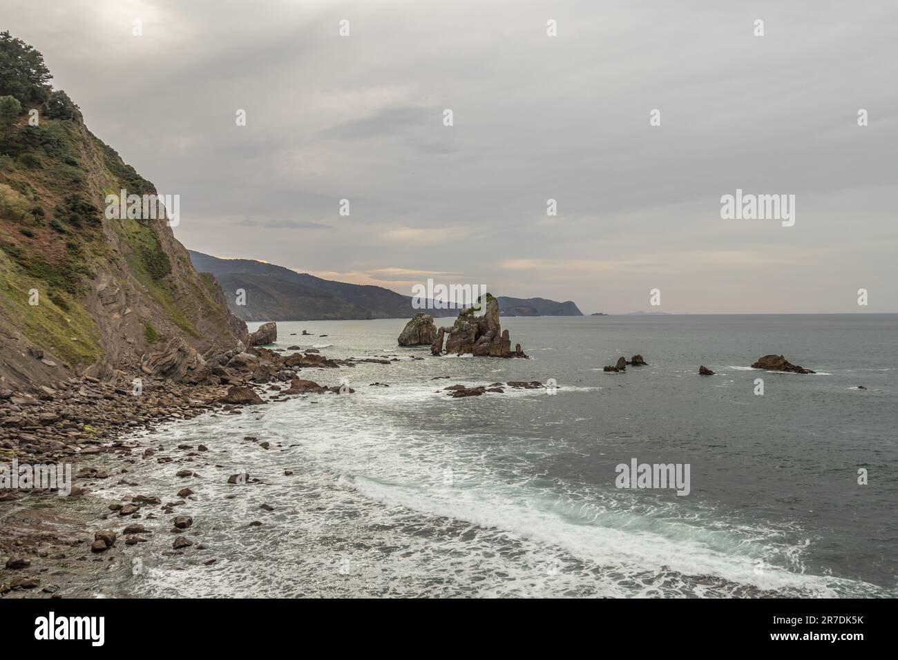 Cliffs and rocks in ocean at San Juan de Gaztelugatxe, a Basque coastal ...