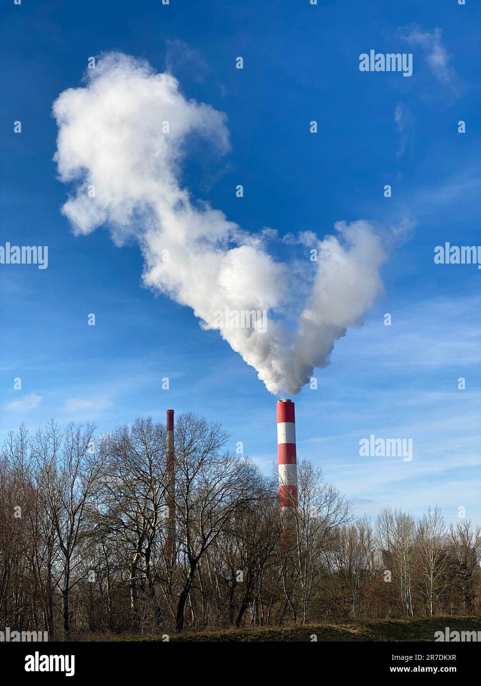 An industrial smokestack emitting white smoke into the atmosphere ...