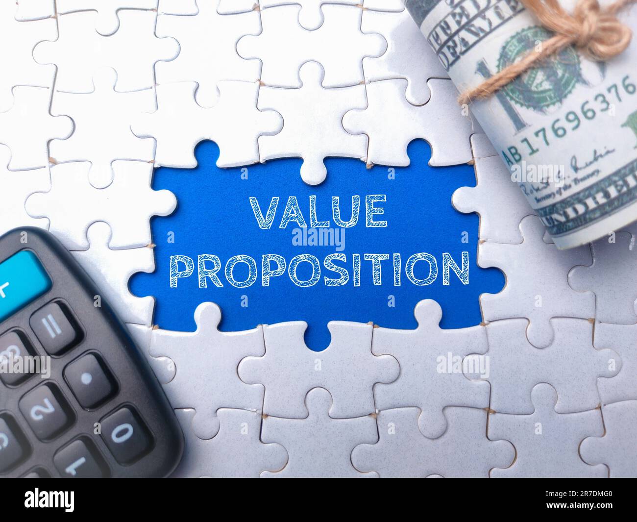 A calculator and puzzle pieces with the word value proposition printed ...