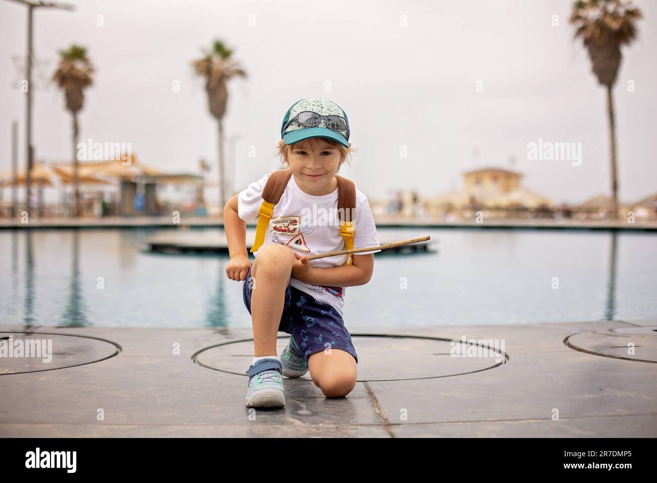 Cute child, boy, playing with water in fountain in Tel Aviv, lights and ...