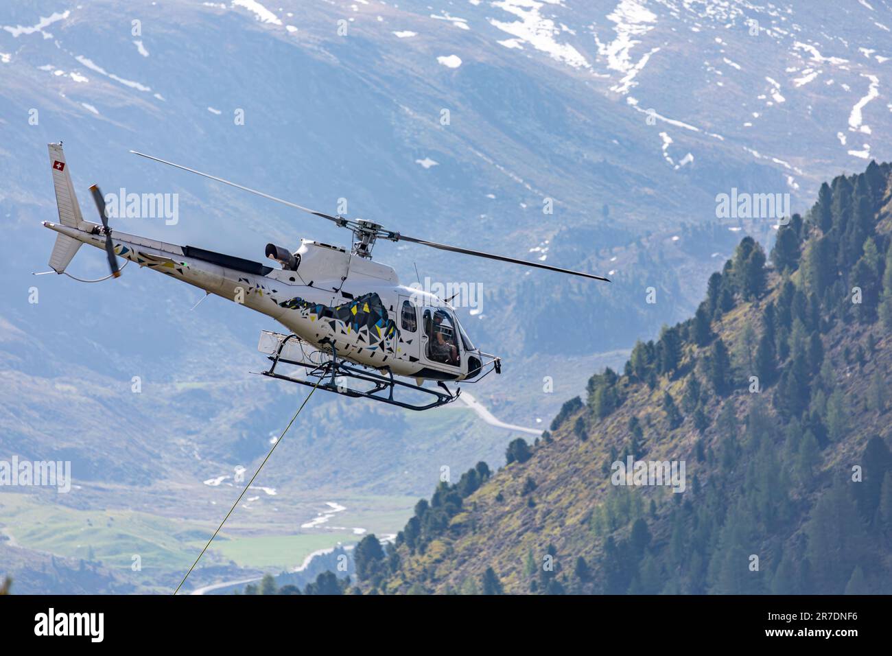 Close-up of a helicopter flying over the forest with attached ...