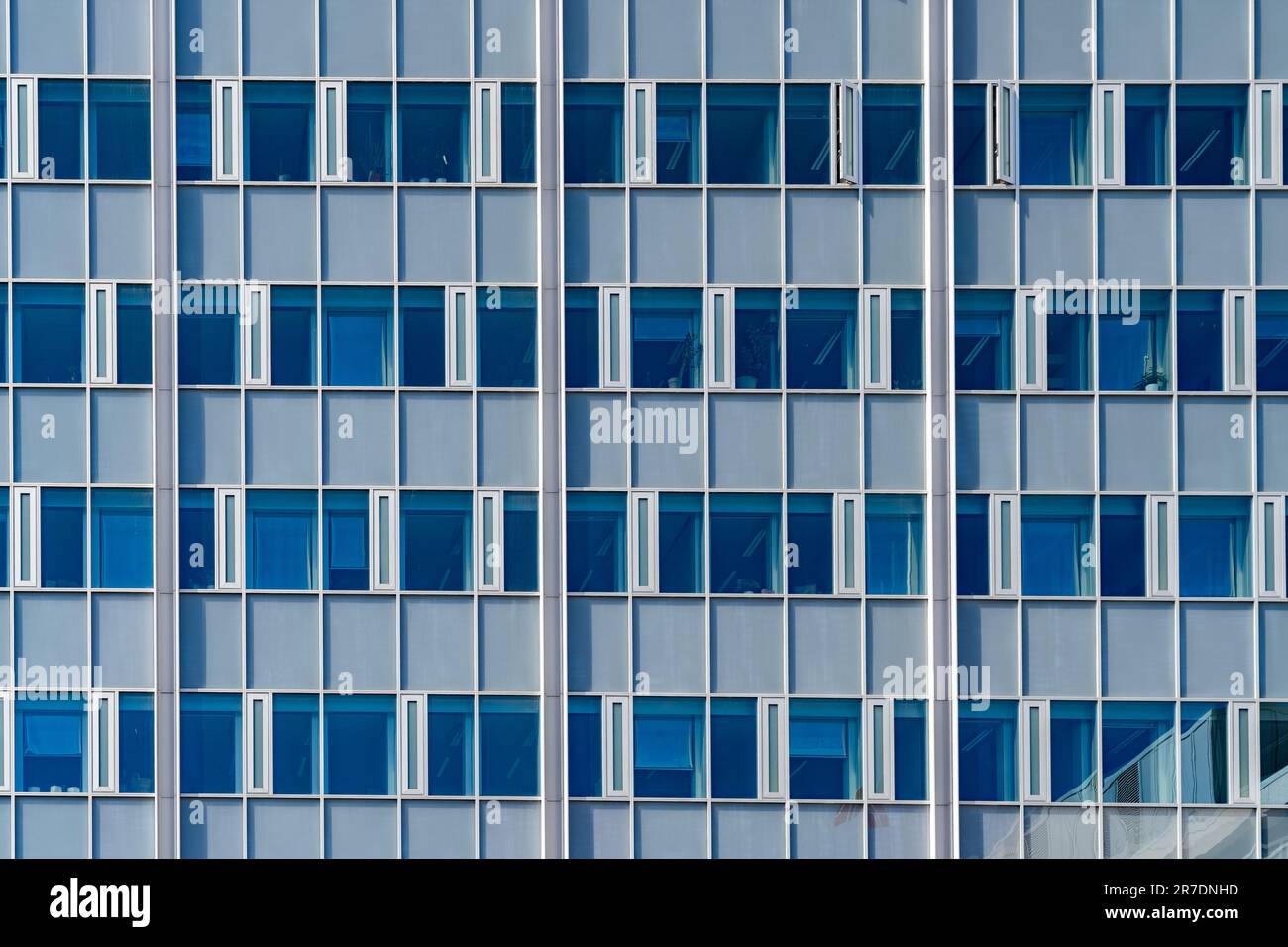 A Facade of a contemporary structure featuring multiple glass windows ...