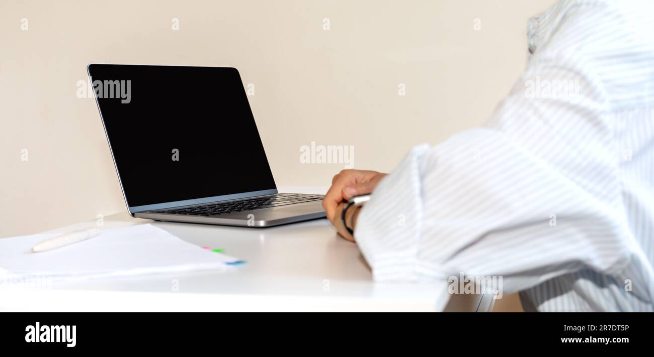 Laptop with blank screen on the desk in front of business person ...