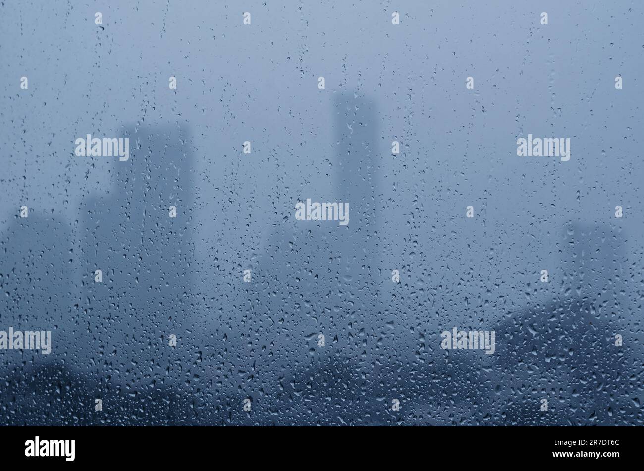 Rain drop on glass window in monsoon season with blurred city buildings ...