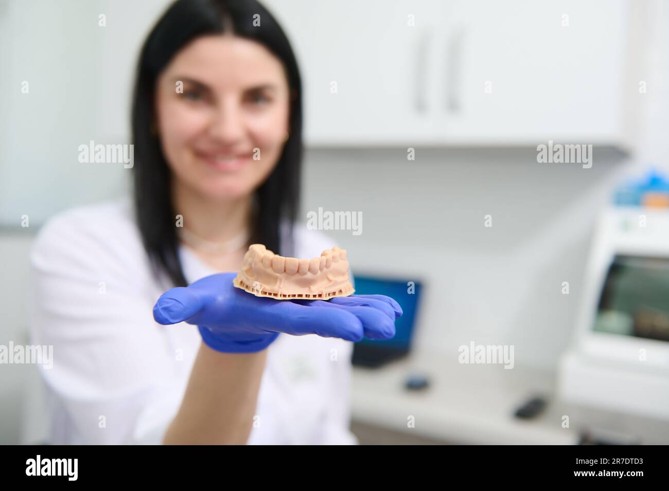 Details: gypsum mold of the human lower jaw in the hand of a blurred ...