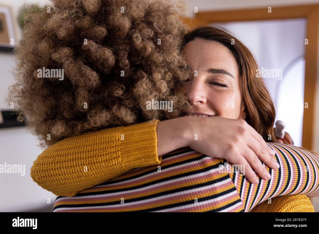 Carefree and joyful female couple hugging each other at home. Head shot ...