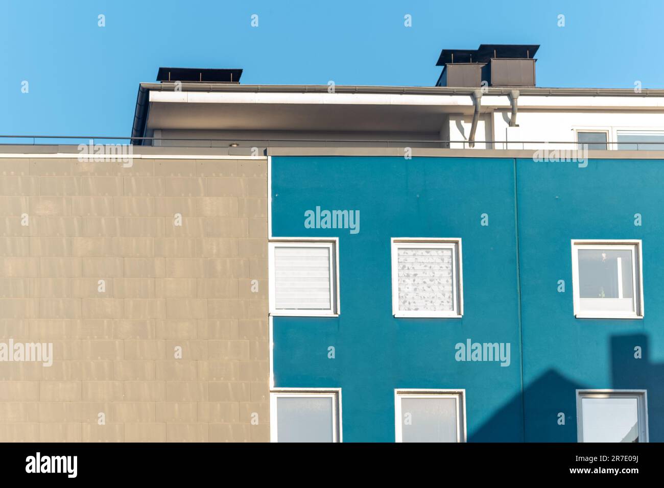 A landscape featuring a tall building with a navy blue facade set ...
