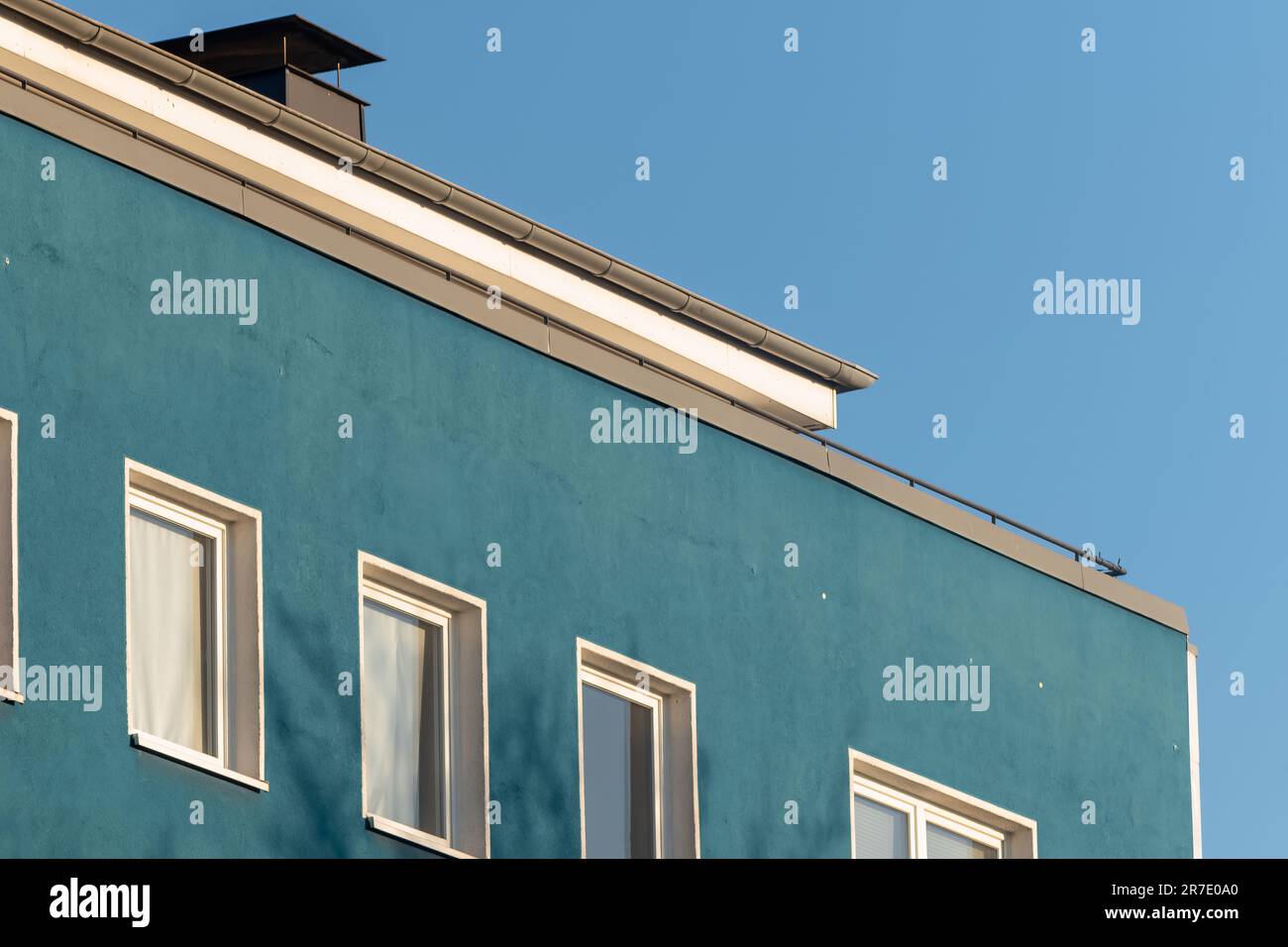 A landscape featuring a tall building with a navy blue facade set ...