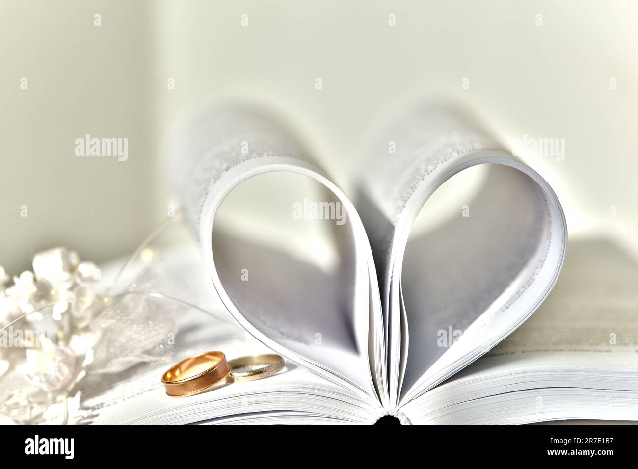 Blurred background of wedding rings and open book An open book with a ...