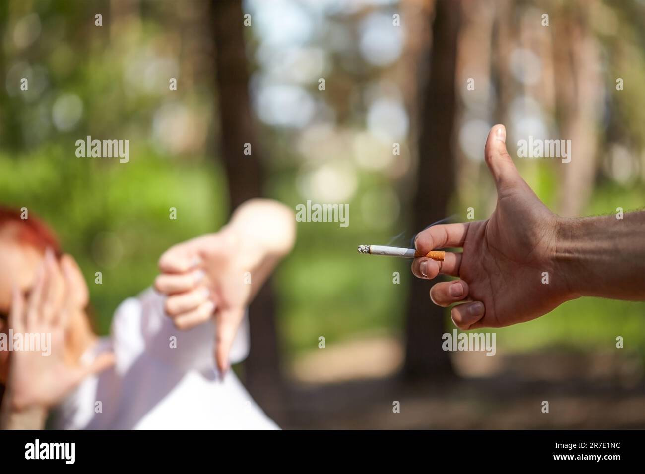 A man offers a cigarette to a girl. Male holding a cigarette and ...