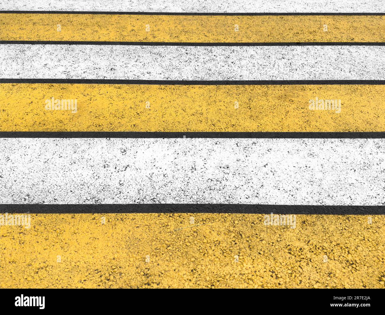 Yellow pedestrian crosswalk across the road with asphalt pavement ...