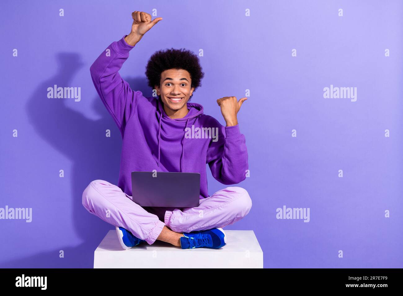 Full size photo of cheerful clever person sit on cube with laptop ...