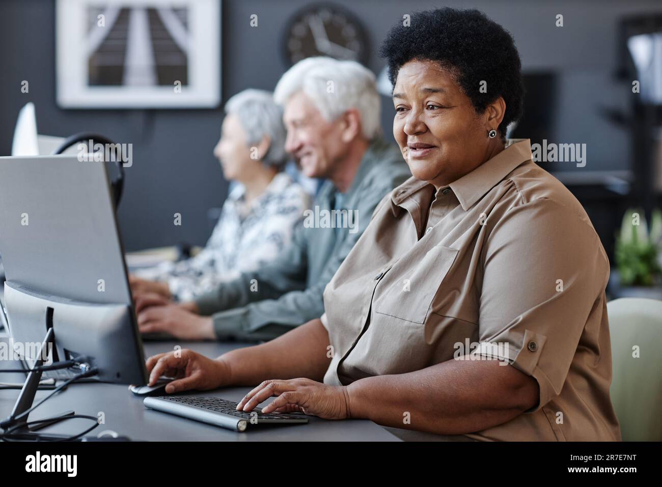 Side view portrait of senior people using computers in row with black ...