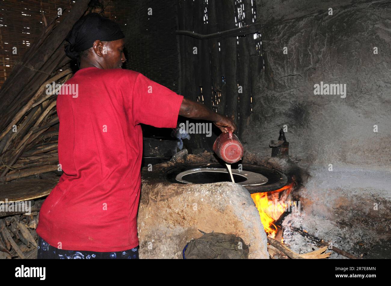 Ethiopian woman cooking injera. Injera is traditional food made with ...