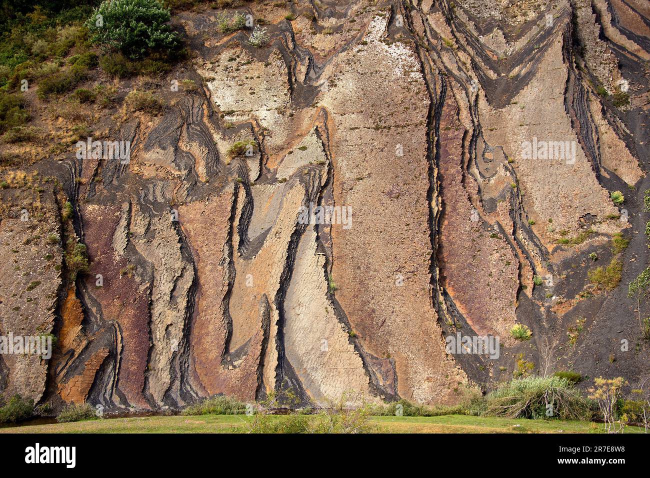 Geological strata of red sandstone and shale rich in organic matter ...