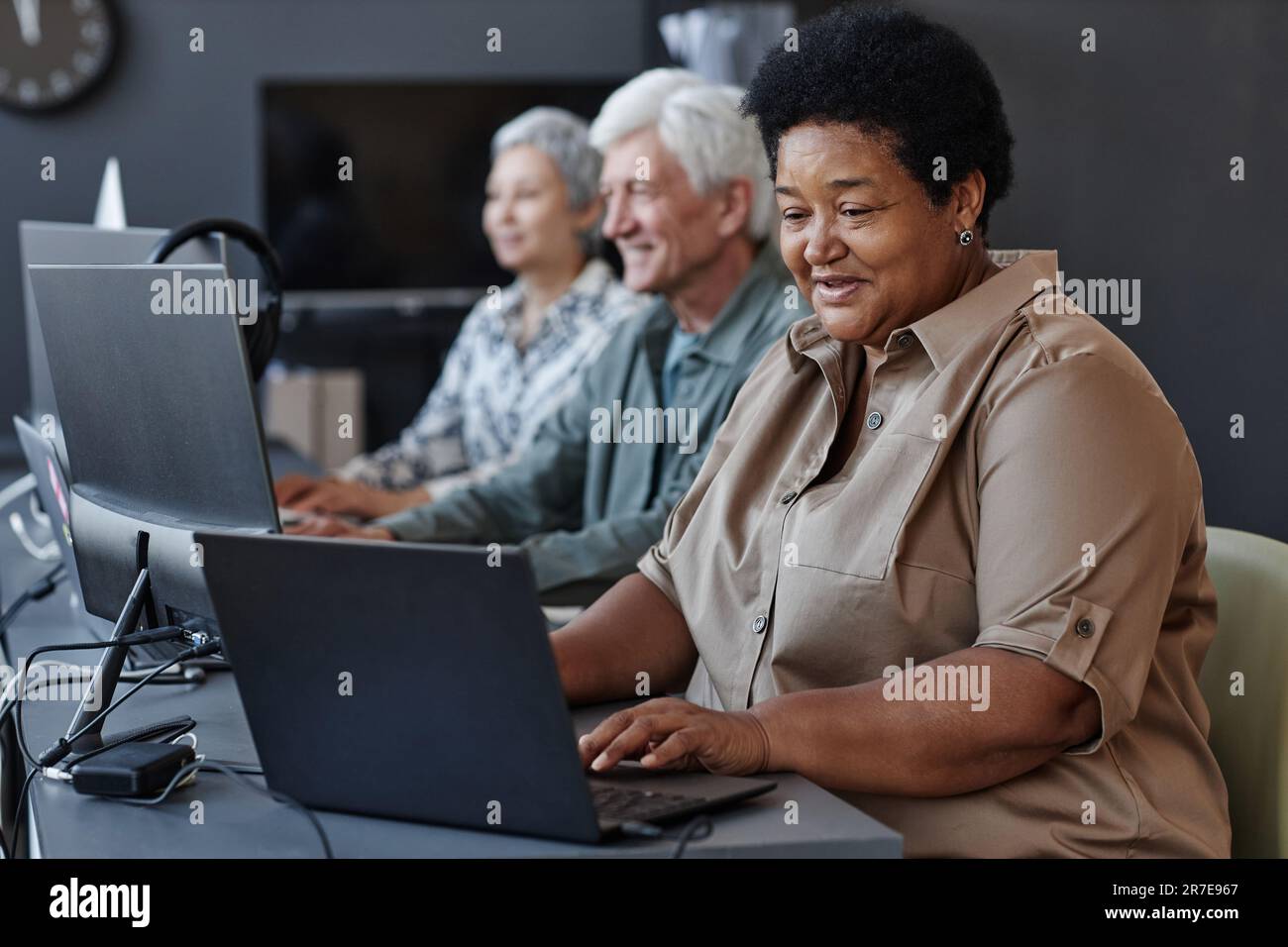 Portrait of senior black woman using computer and smiling in computer ...