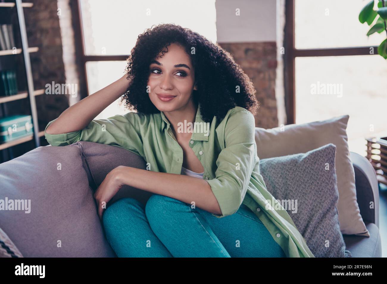 Photo of charming positive person sitting comfy couch hand touch head ...