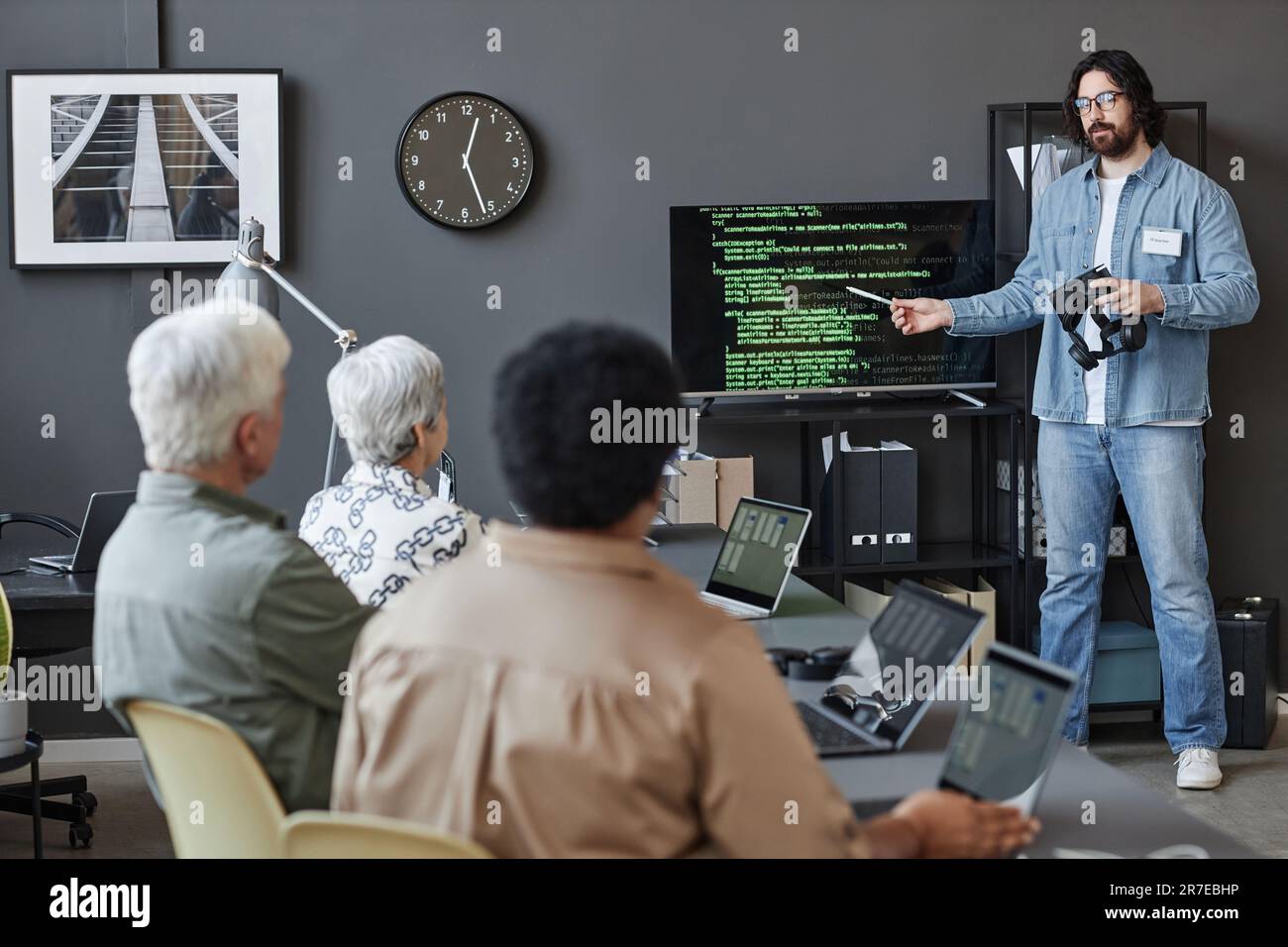 Full length portrait of bearded man pointing at screen with code while ...