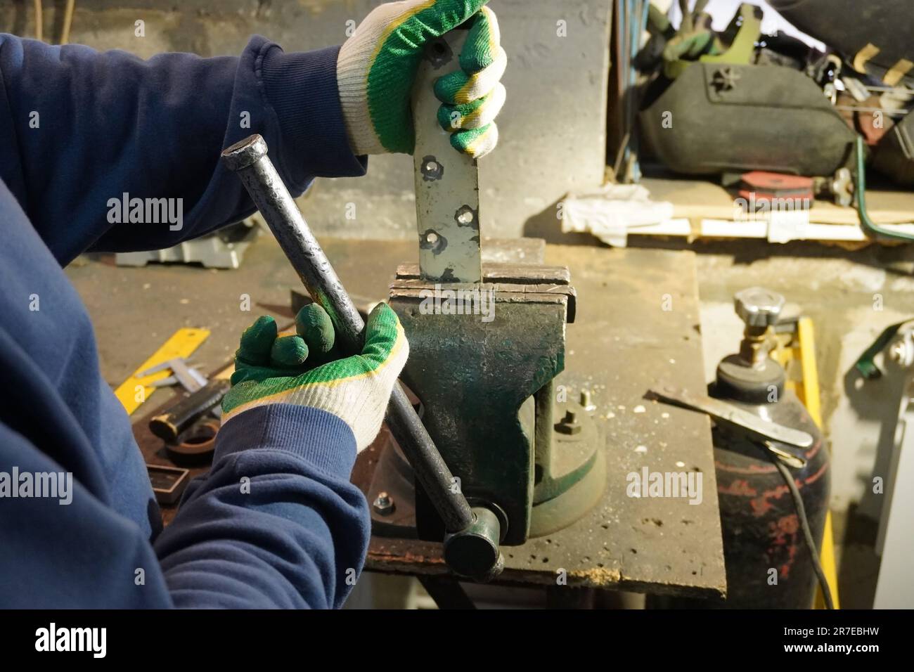 a man works in a garage with pieces of iron Stock Photo - Alamy