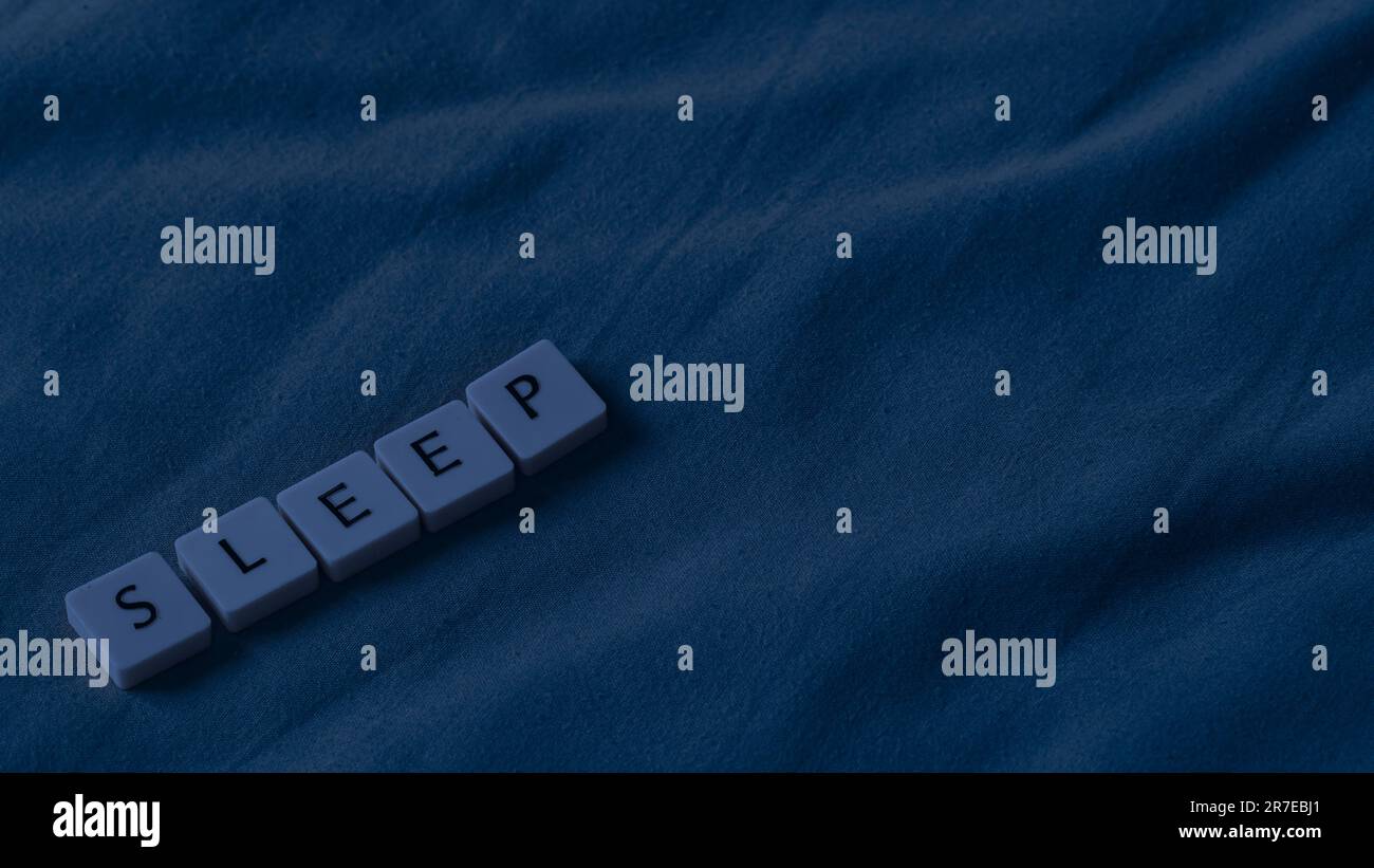 Sleep concept. Sleep lettering on a soft bed sheet. Copy space for text ...