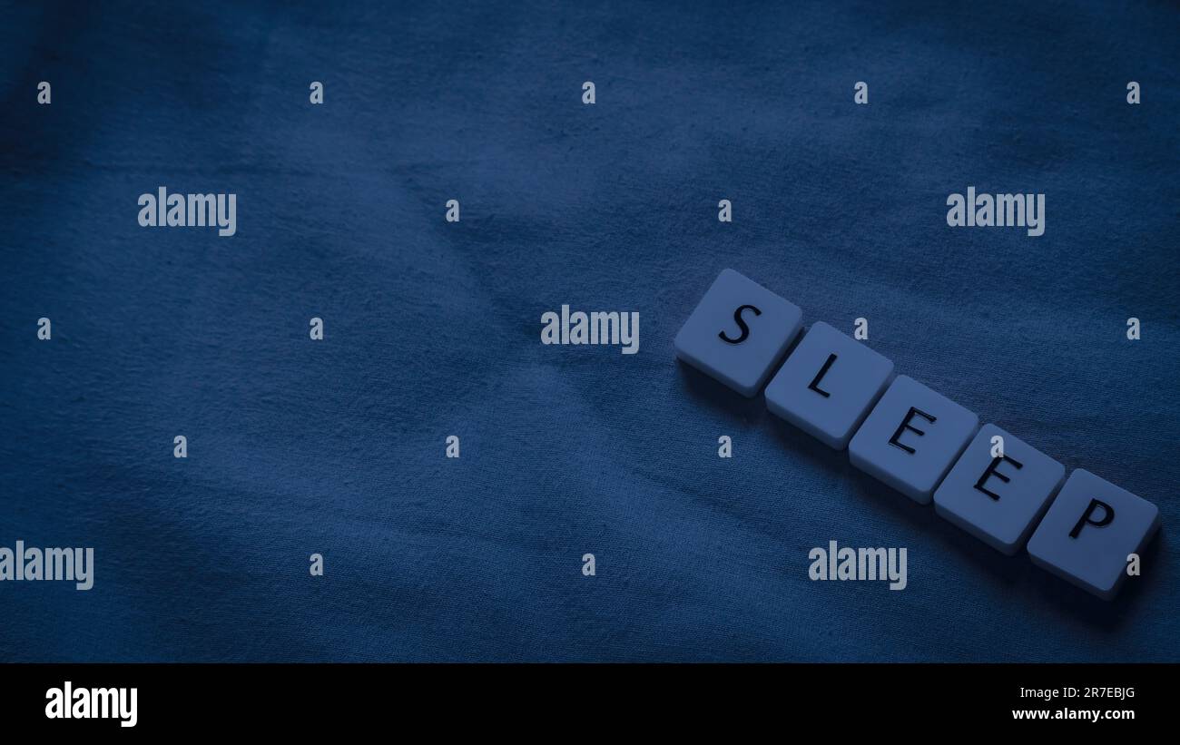 Sleep concept. Sleep lettering on a soft bed sheet. Copy space for text ...