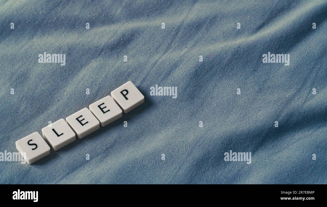 Sleep concept. Sleep lettering on a soft bed sheet. Copy space for text ...