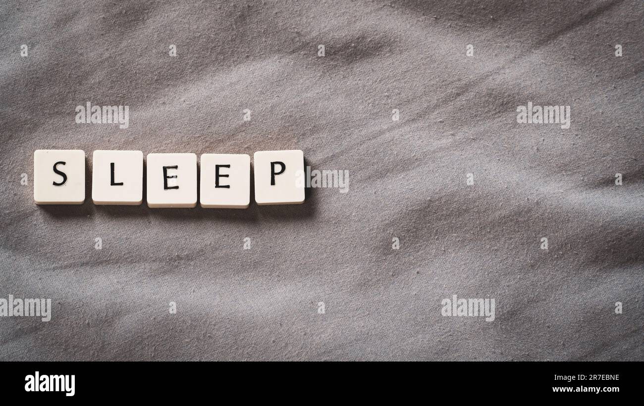 Sleep concept. Sleep lettering on a soft bed sheet. Copy space for text ...