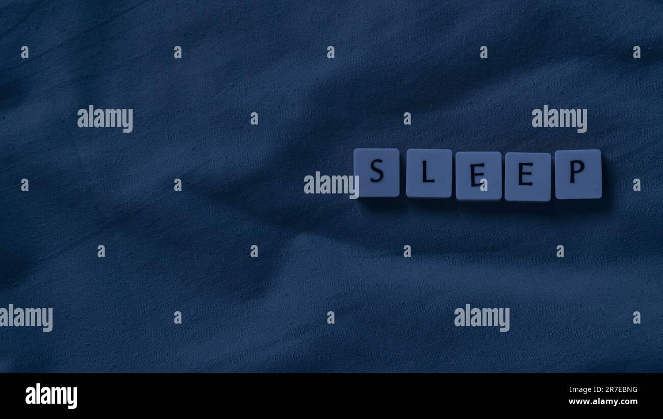 Sleep concept. Sleep lettering on a soft bed sheet. Copy space for text ...