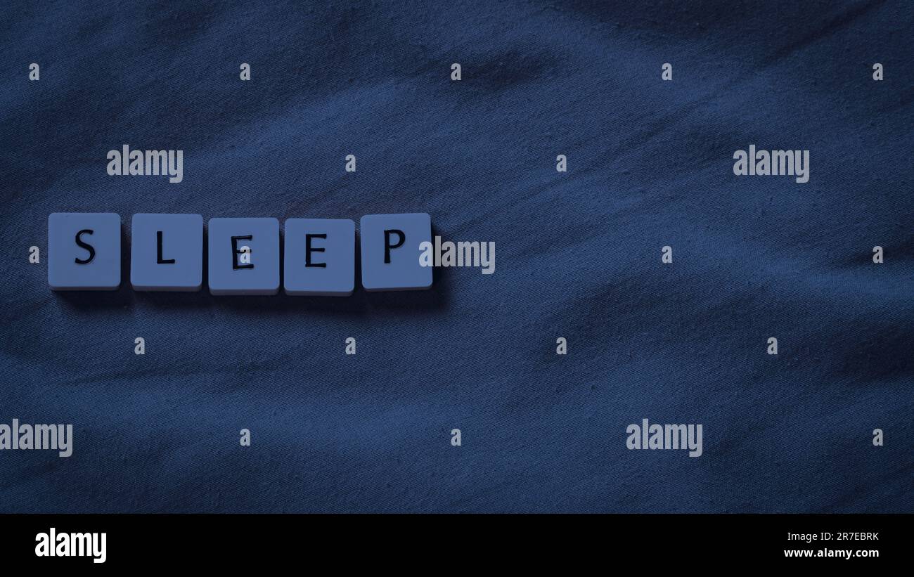 Sleep concept. Sleep lettering on a soft bed sheet. Copy space for text ...