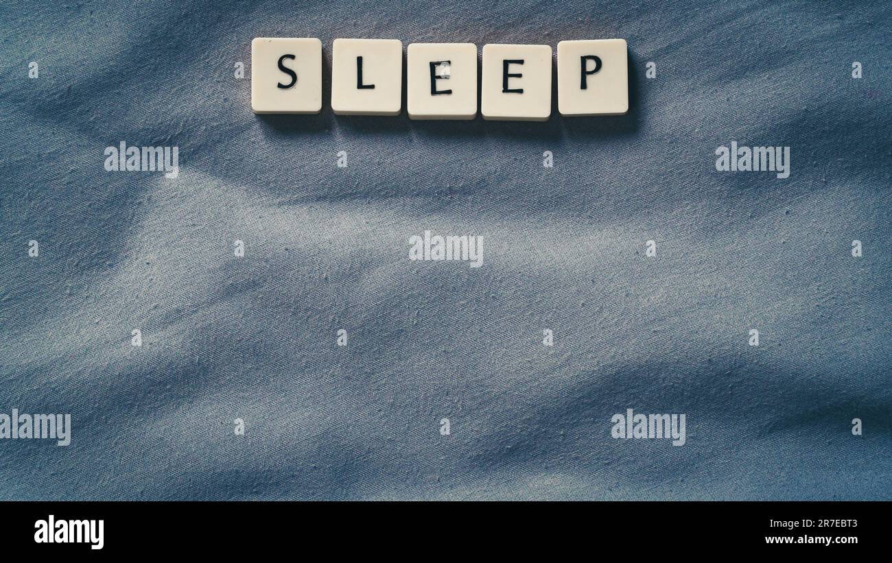 Sleep concept. Sleep lettering on a soft bed sheet. Copy space for text ...