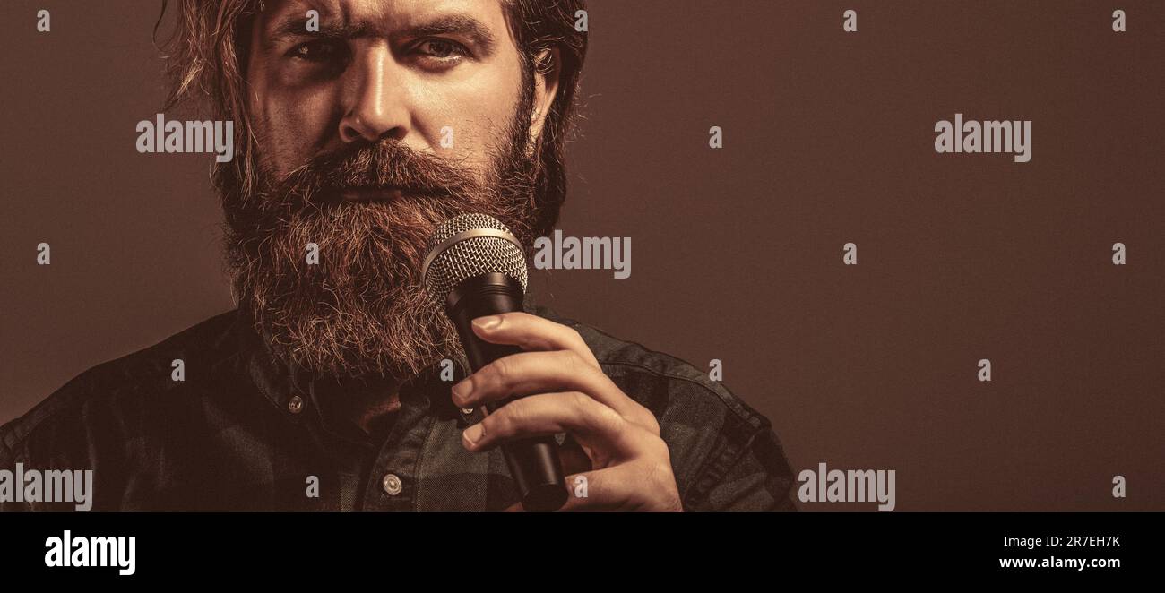 Male attends karaoke. Bearded man singing with microphone. Male singing ...