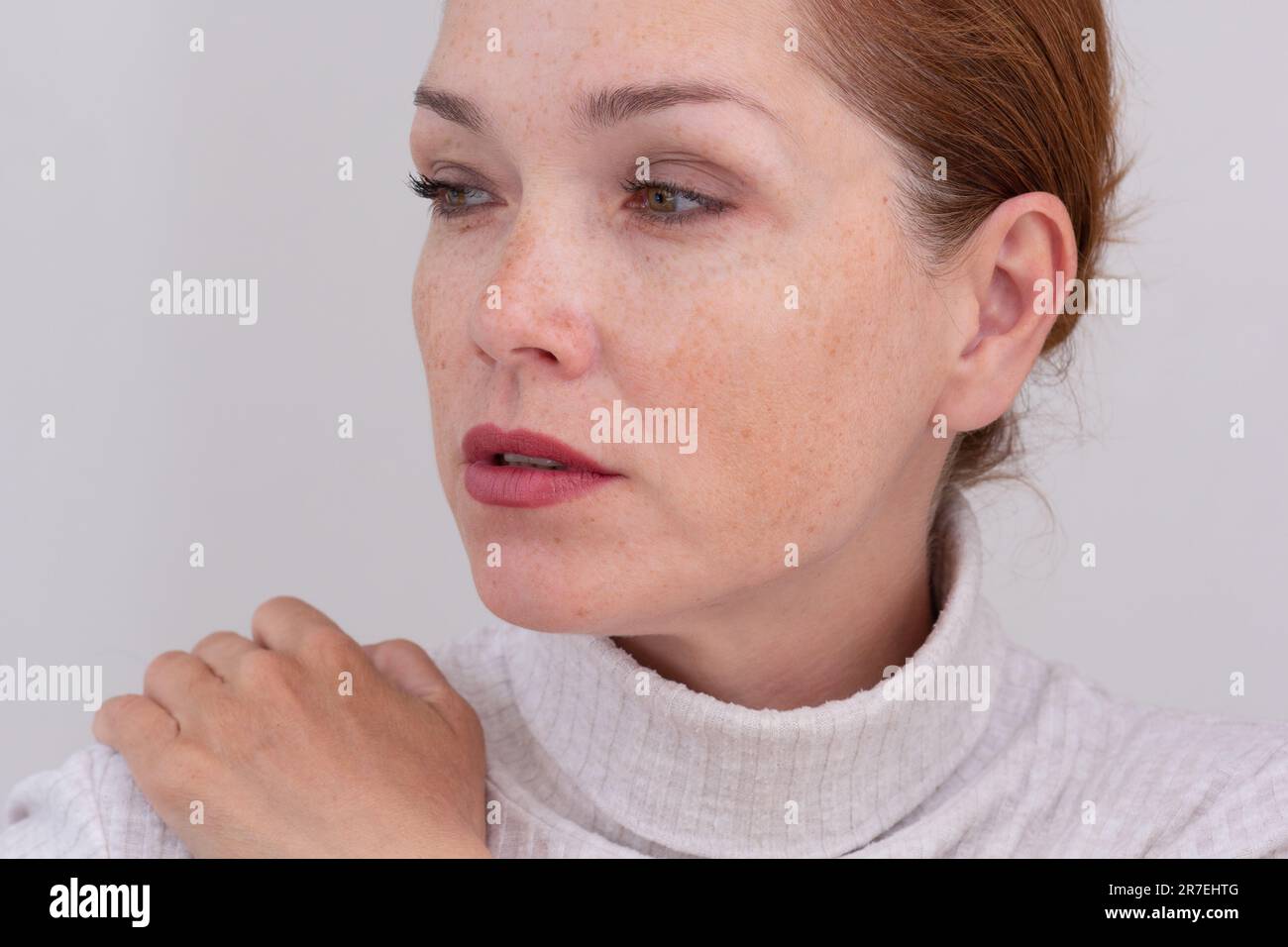 Portrait of cropped caucasian middle aged woman face with freckles on white background looking ...