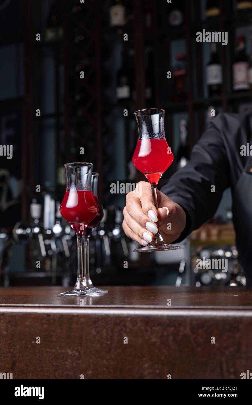 A bartender preparing drinks for guests in a bar setting Stock Photo ...