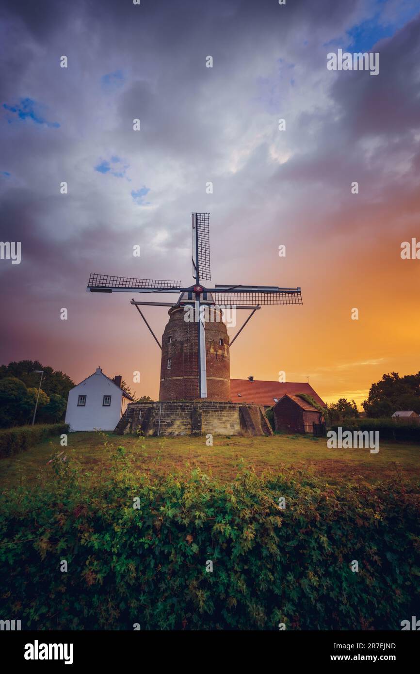 A scenic view of a traditional windmill standing proudly next to a charming white house Stock ...