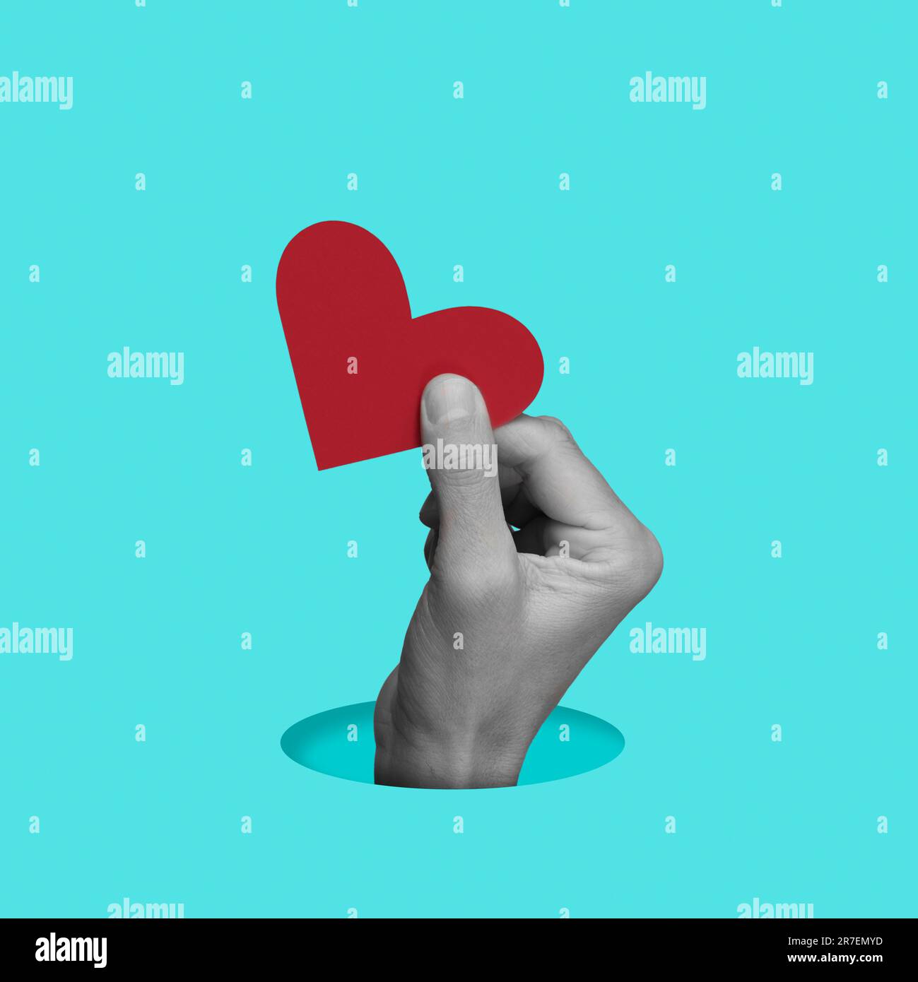 the hand of a man in black and white holding a red heart popping out of ...