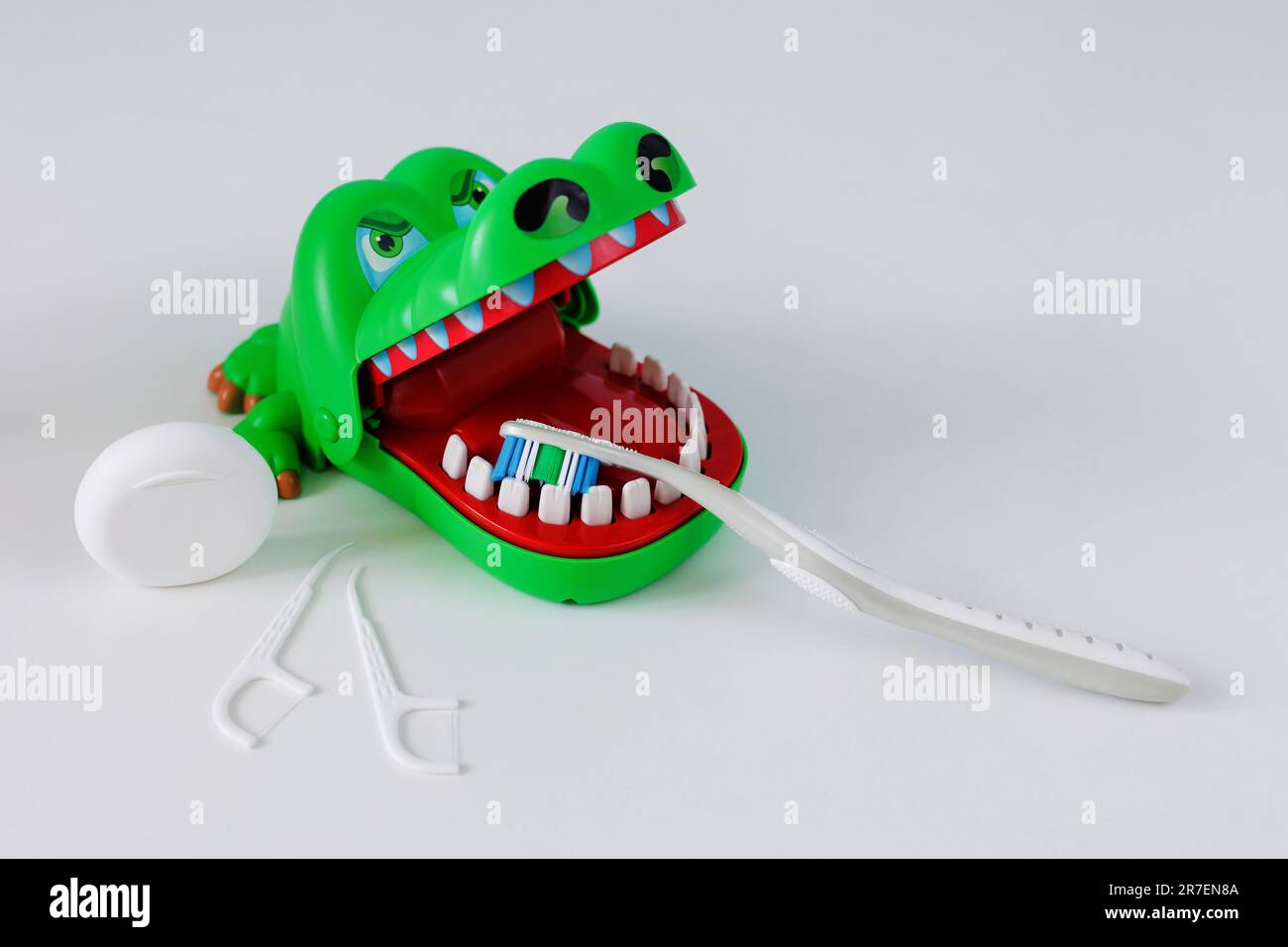Dental floss, toothpicks, brush and crocodile on white background Stock ...