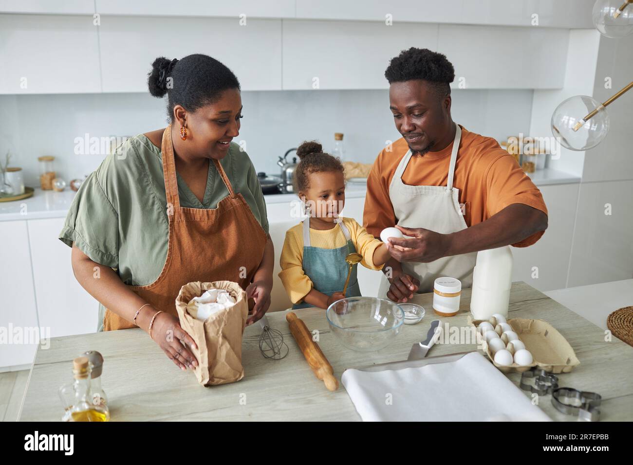 African American family baking together in the kitchen with their ...