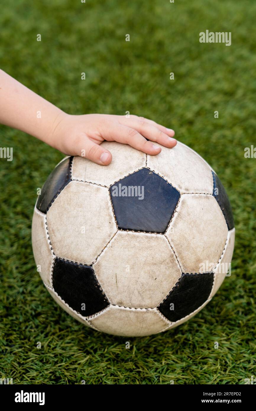 Old shabby classic football in boy's hand Stock Photo - Alamy