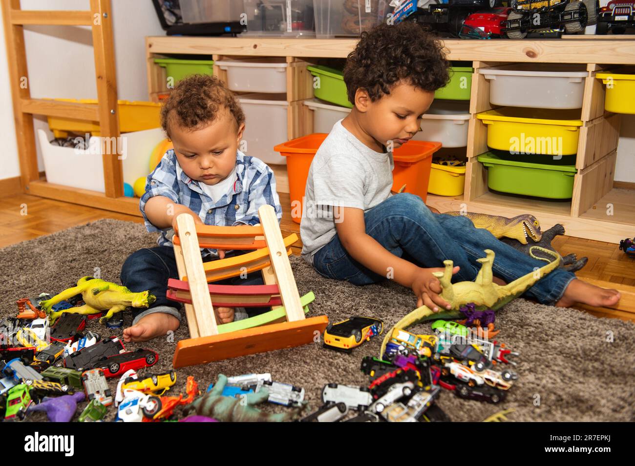 Two funny and messy baby brothers playing together in kids room Stock ...