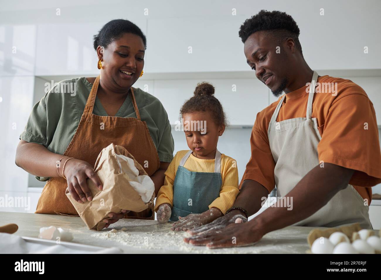African American family using flour for baking together with their ...