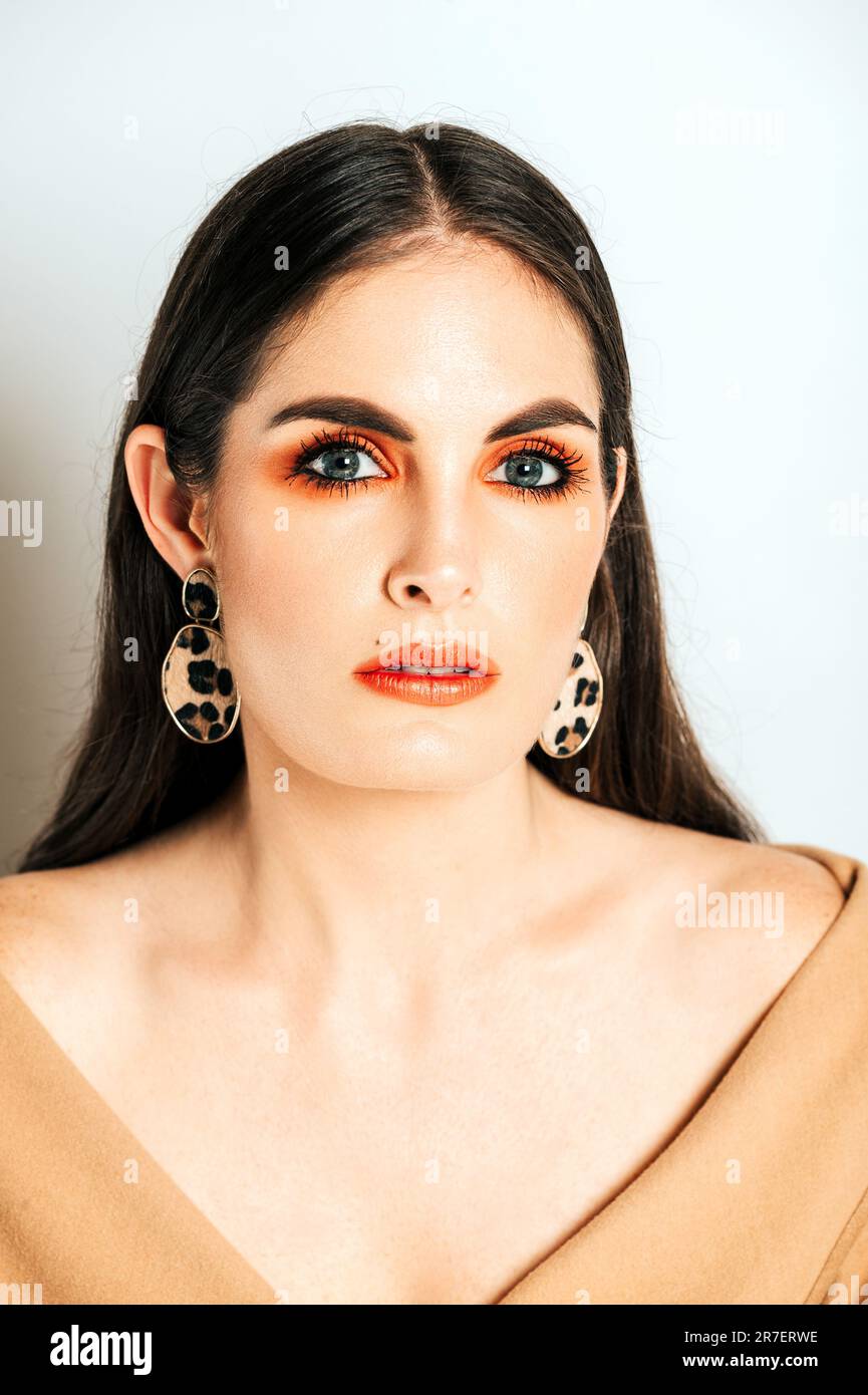 Studio shot of beautiful young woman with dark hair and blue eyes ...