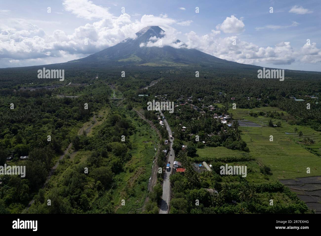 Vehicles make their way on a road near Mayon volcano as it continues to ...