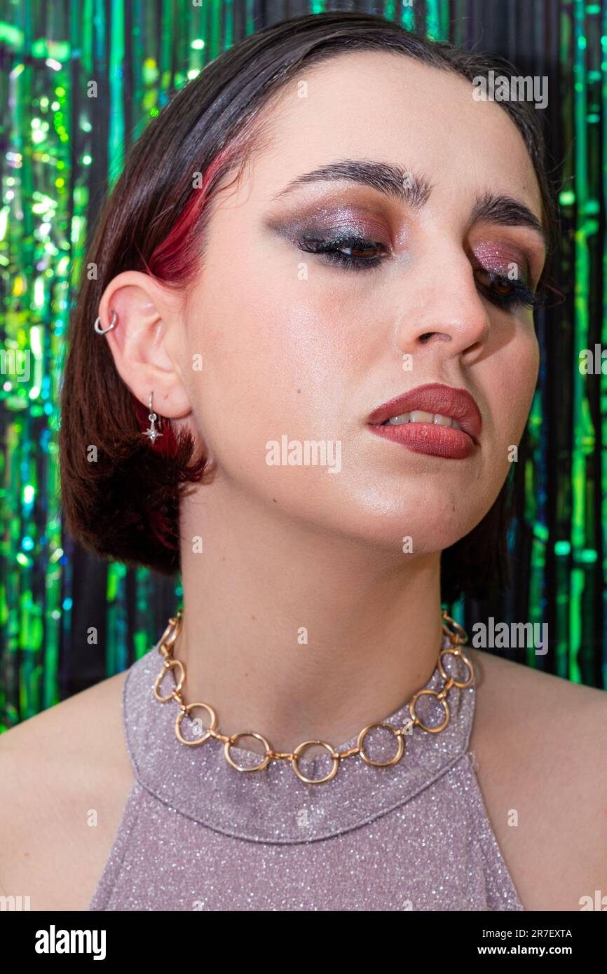 A female model wearing gold jewelry is posing confidently in a ...