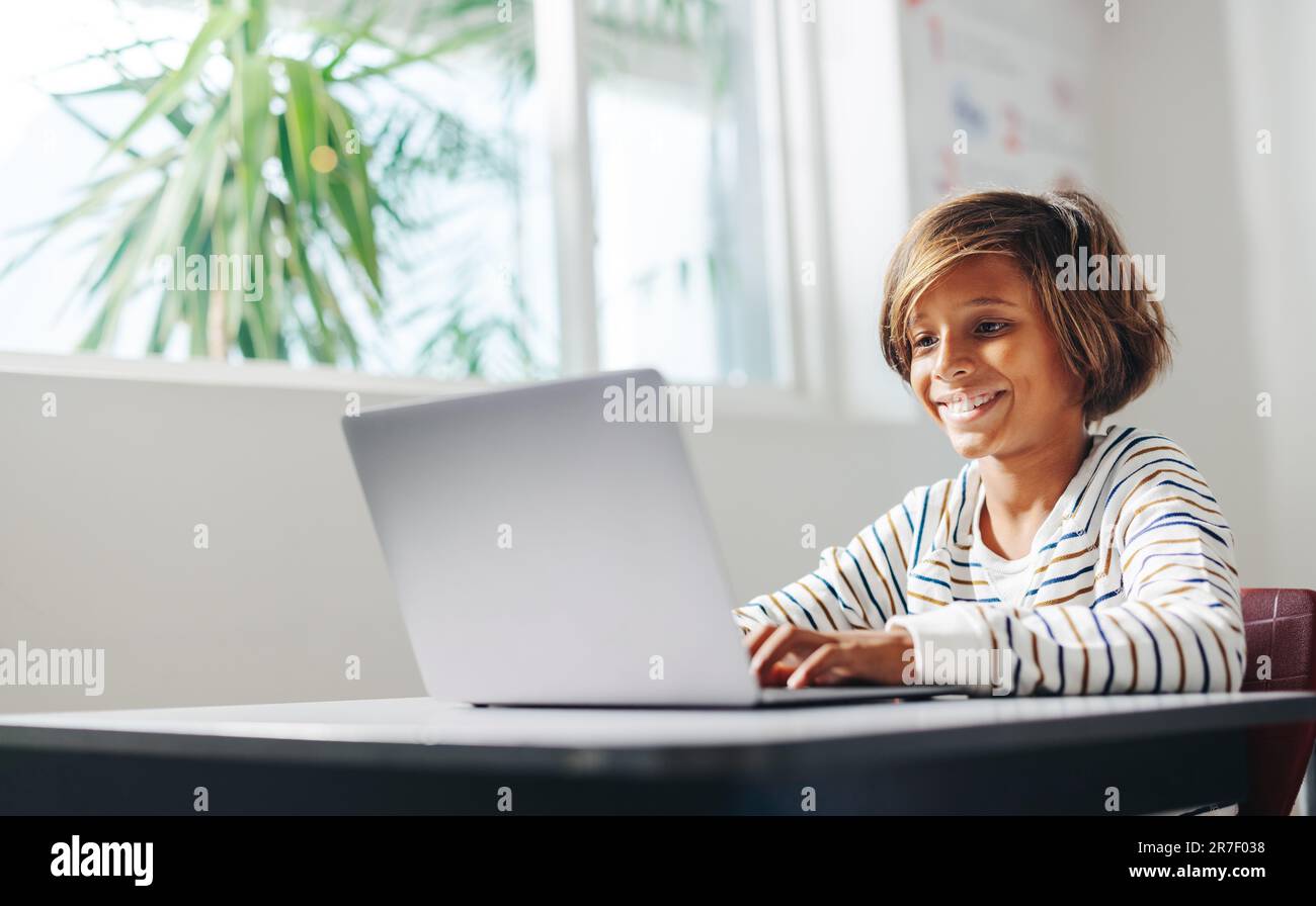Excited young kid learning to code in a computer science class. Sitting ...