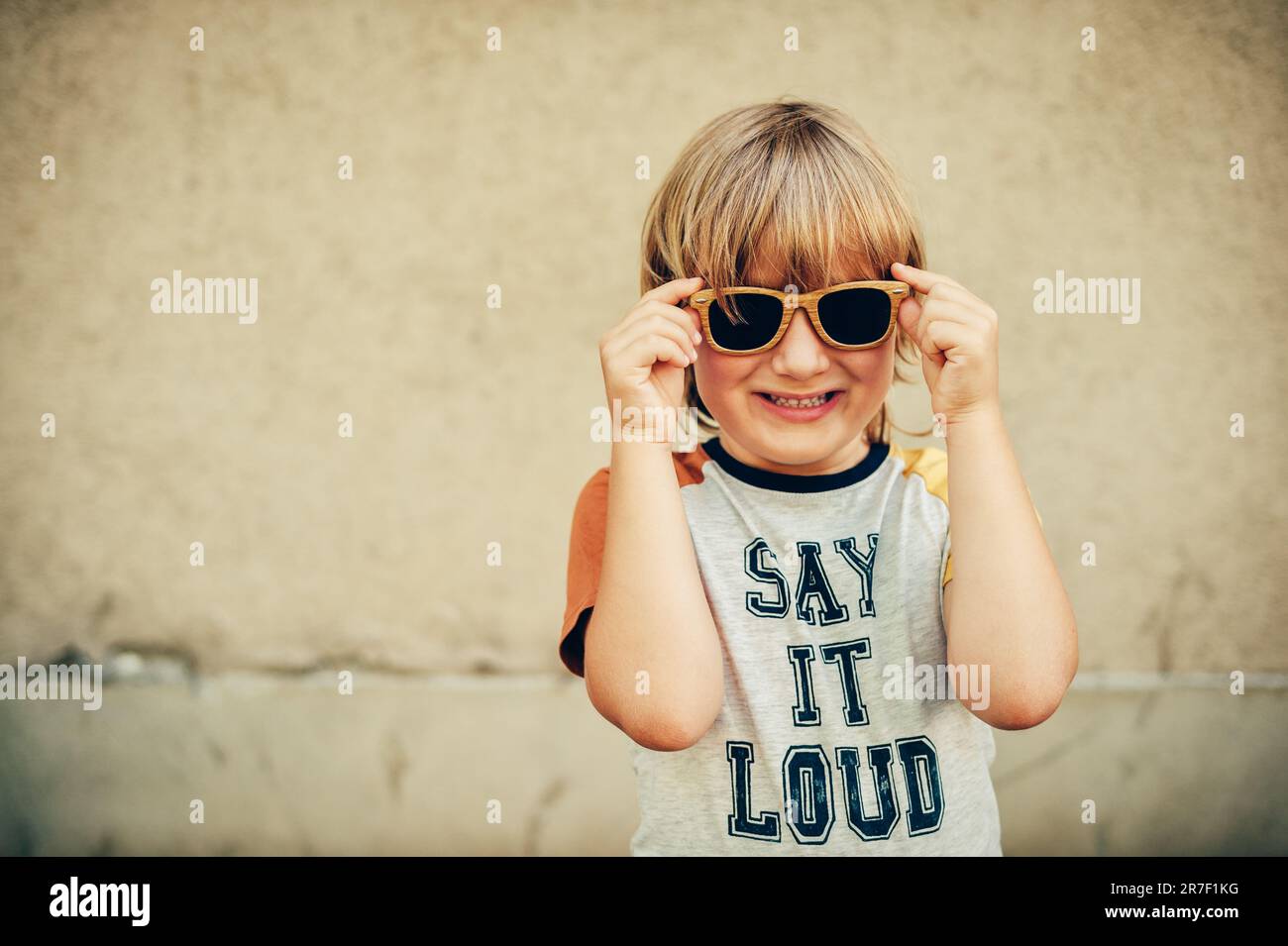 Outdoor portrait of funny little boy wearing sunglasses and t-shirt ...