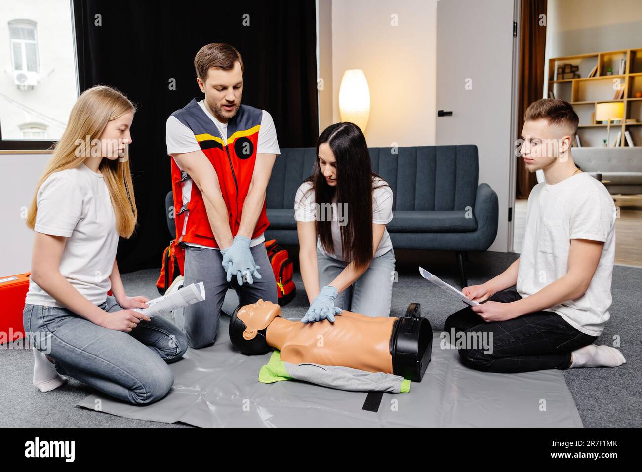 Group of people learning how to make first aid heart compressions with ...