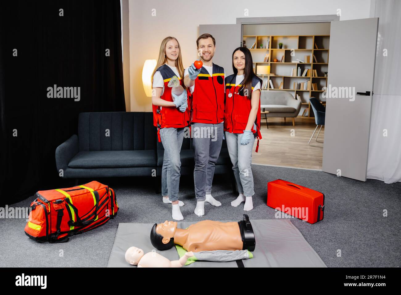 Group of people with cpr dummy looking at camera and smiling after ...