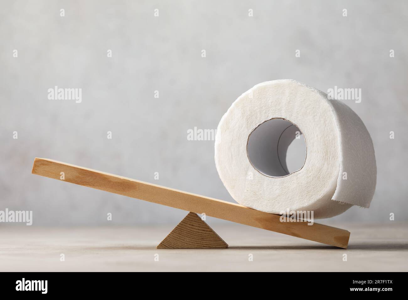 Toilet paper roll on wooden swing or scales on abstract background ...
