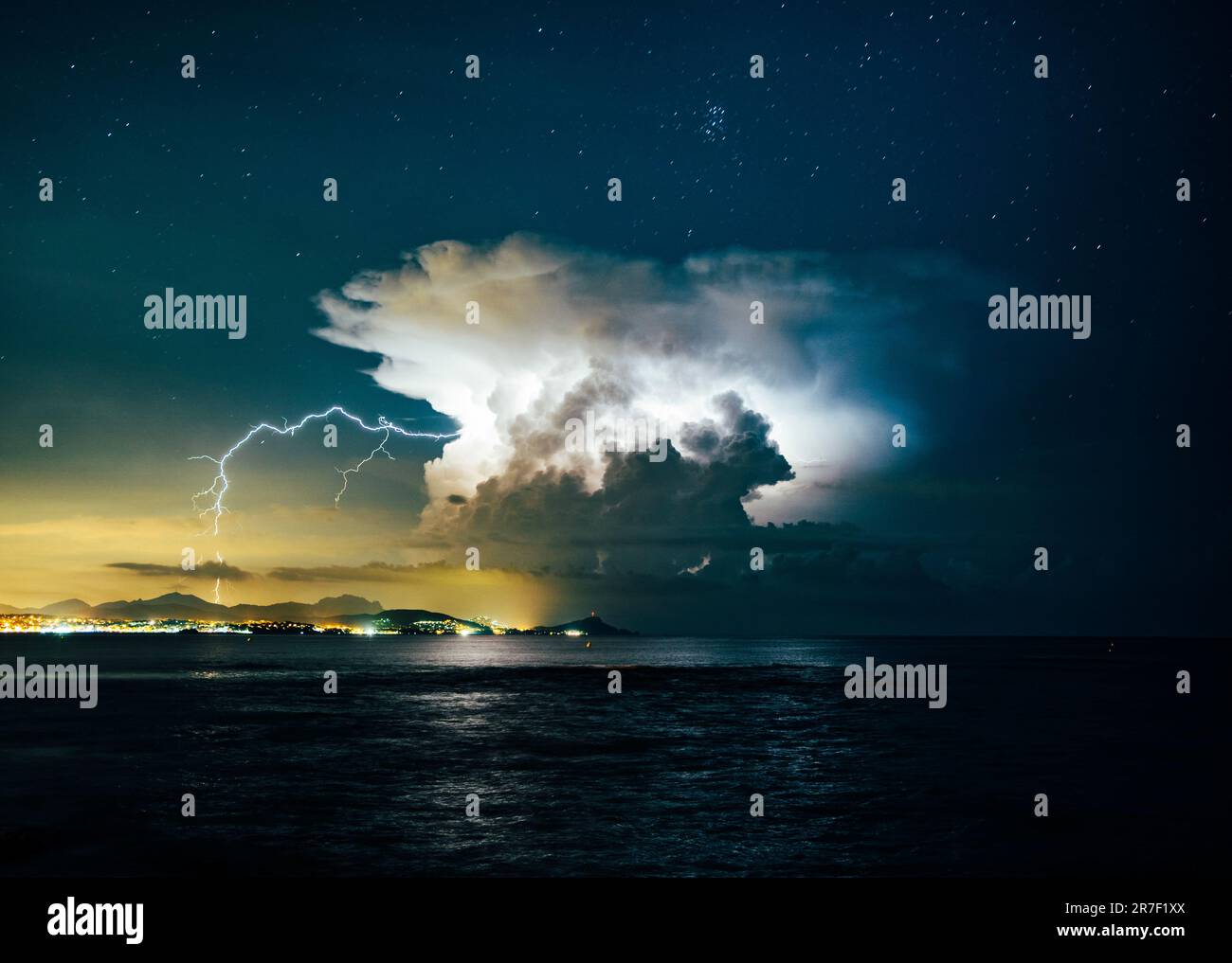 A bright lightning bolt illuminates a majestic mountain landscape in ...